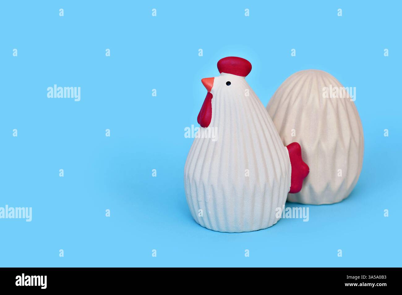 Ceramic Easter chicken and egg decoration objects on blue background ...