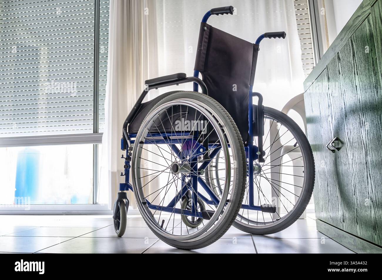 Empty wheelchair inside a room Stock Photo - Alamy