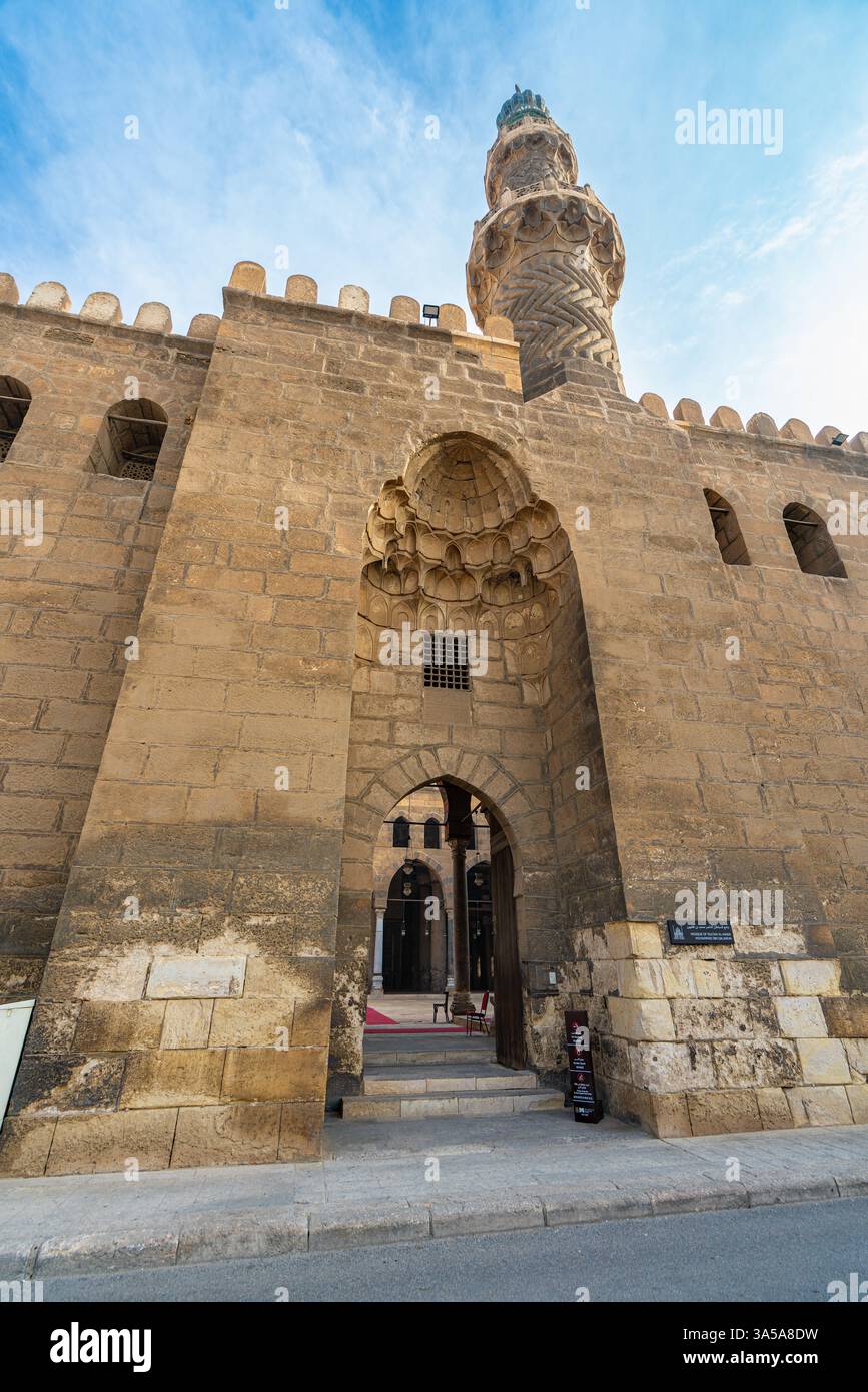 The ornate entrance of Mohamed Ali Mosque in Cairo, Egypt, features a detailed minaret and stone ...