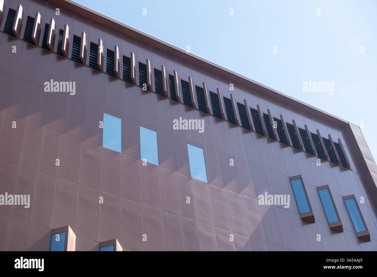 A modern building facade featuring a geometric pattern of vertical and ...