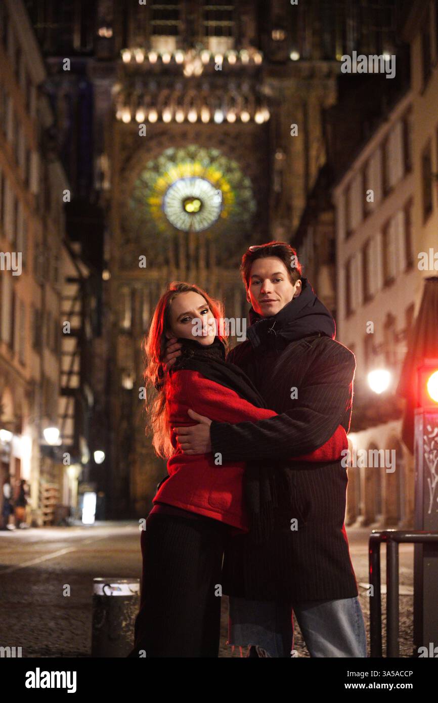 Romantic nighttime moment in Strasbourg, with a couple hugging in front ...