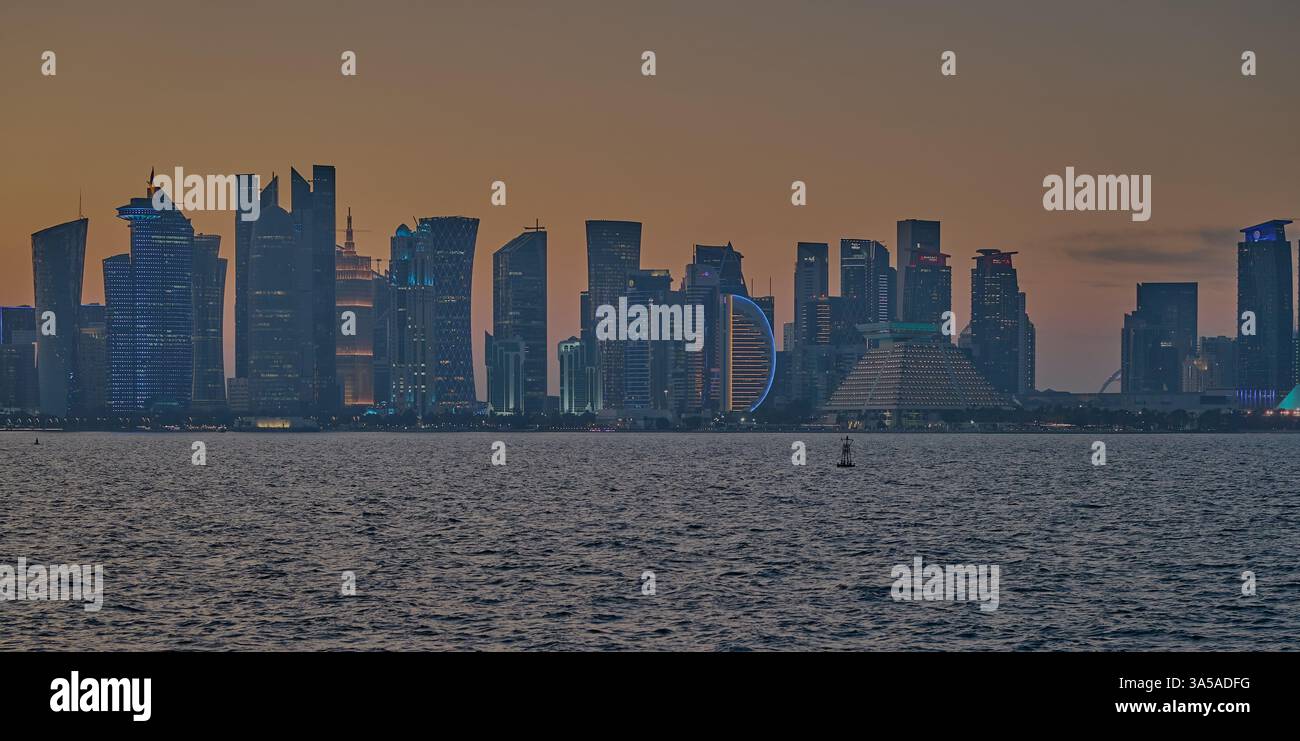 Doha Qatar skyline from the Corniche street at dusk with dhows in the ...