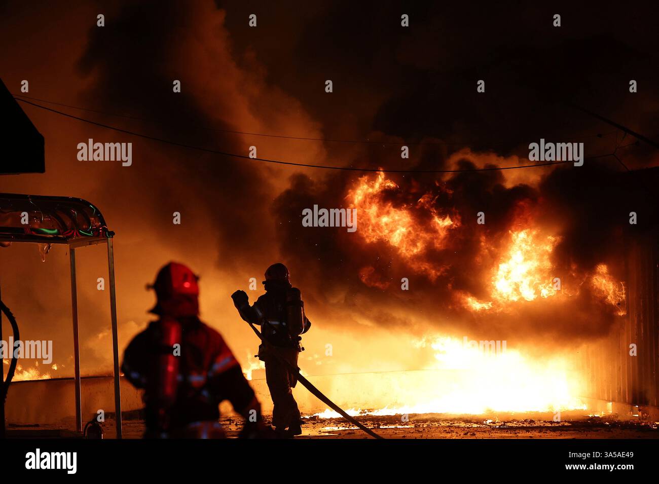 Firefighters extinguish a fire at a factory building that has been ...