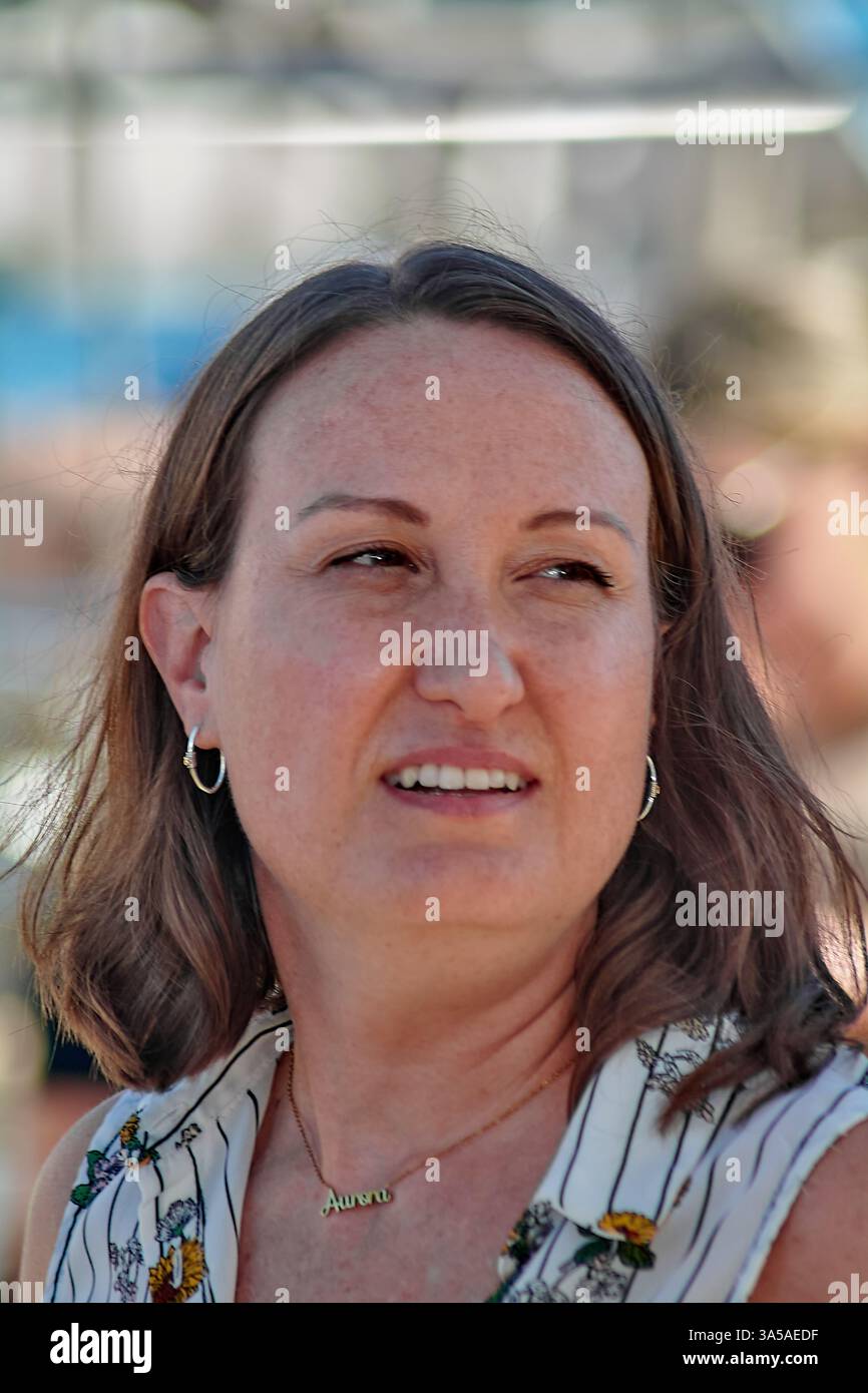 A cheerful woman with short hair and freckles, looking directly at the ...