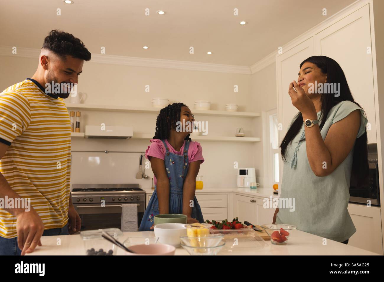 Family enjoying quality time preparing fresh fruit snacks together in ...