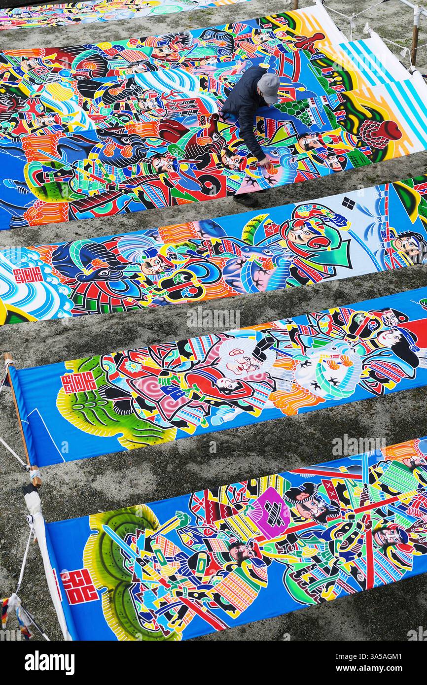 A craftsman dries about 9-meter-long vividly painted samurai flags in ...