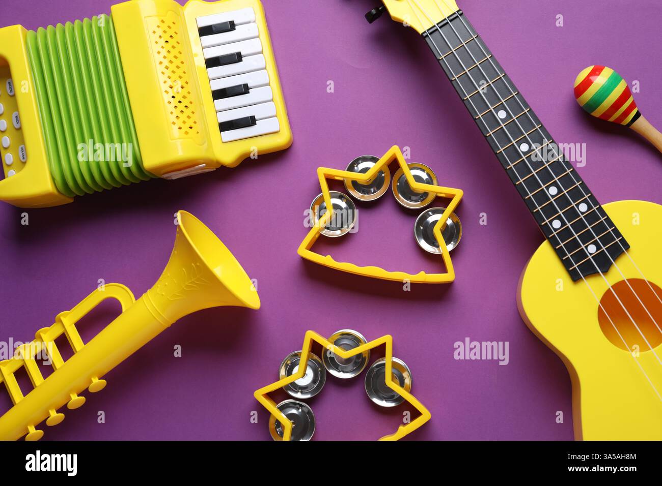 Flat lay composition with different toy musical instruments on violet ...