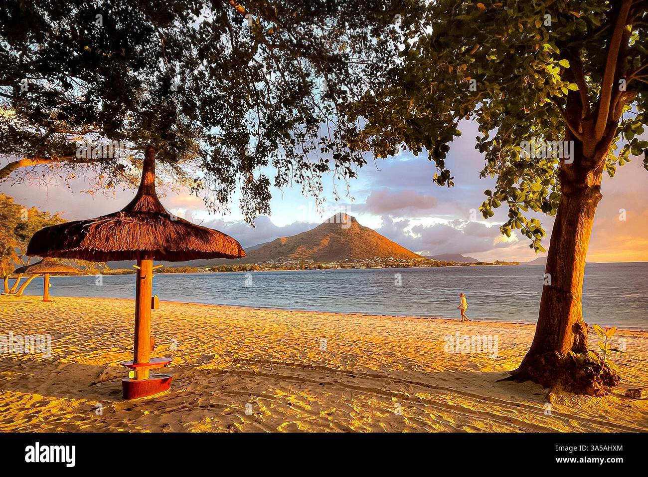 The sun sets, illuminating the Tamarin Mountain, as seen from the beach ...