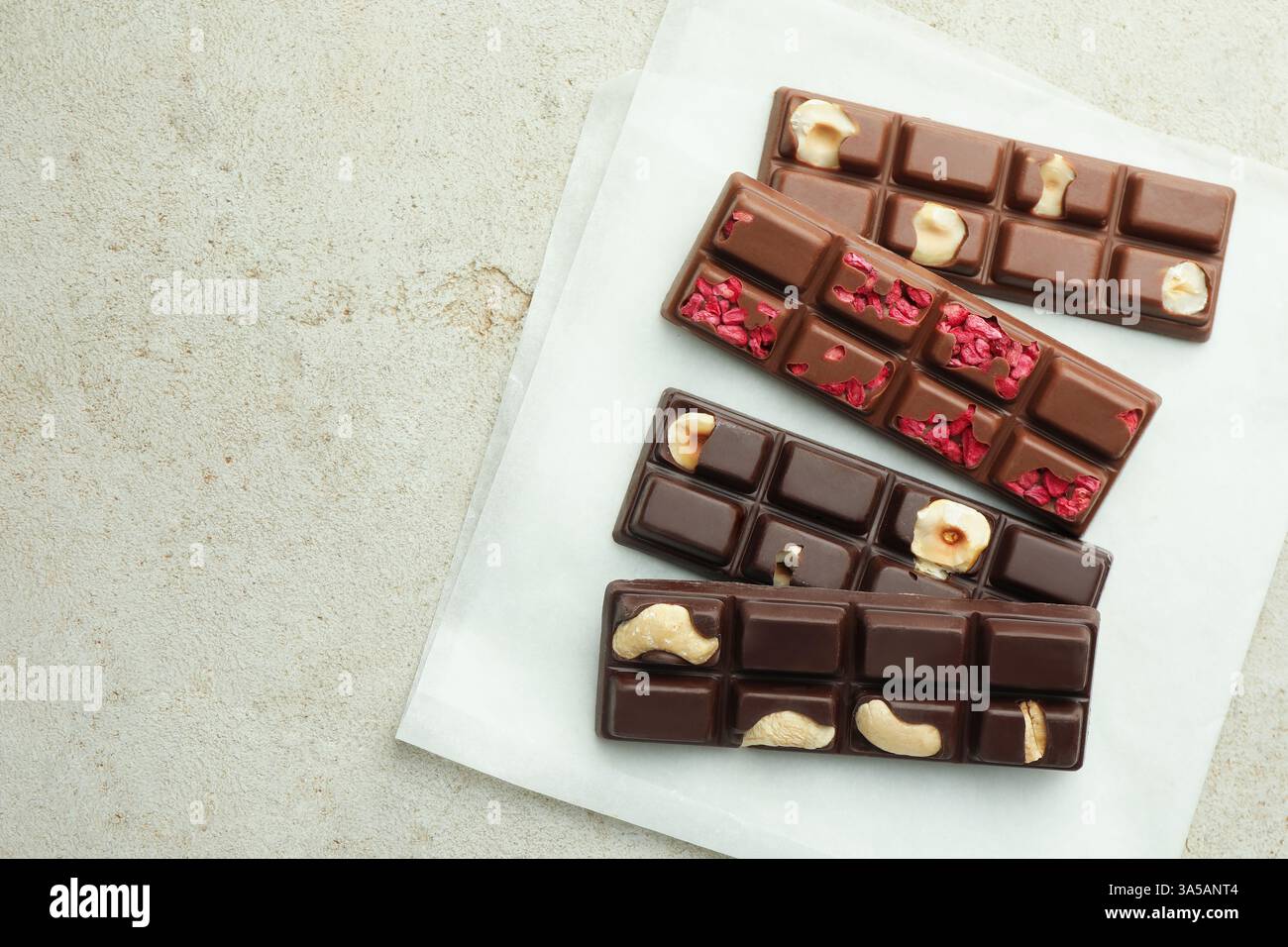 Delicious chocolate bars with different flavors on light table, flat ...