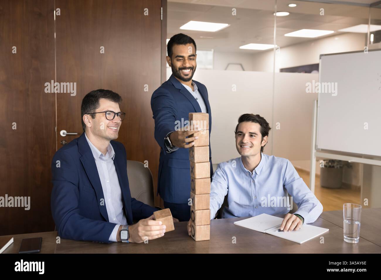 Multiethnic business team building tower from wooden bricks Stock Photo ...