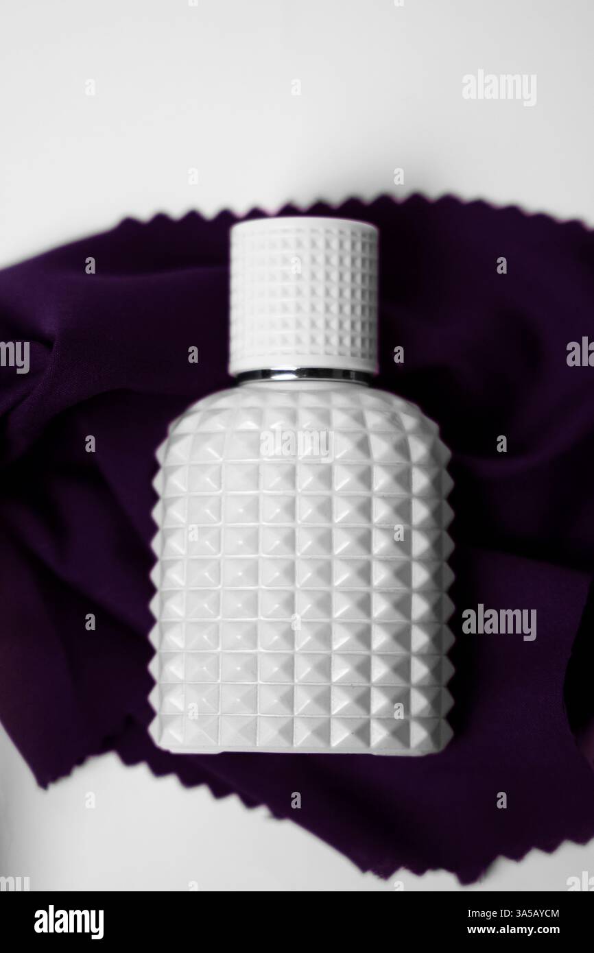 A high-quality photo of a luxury white perfume bottle, highlighting its ...