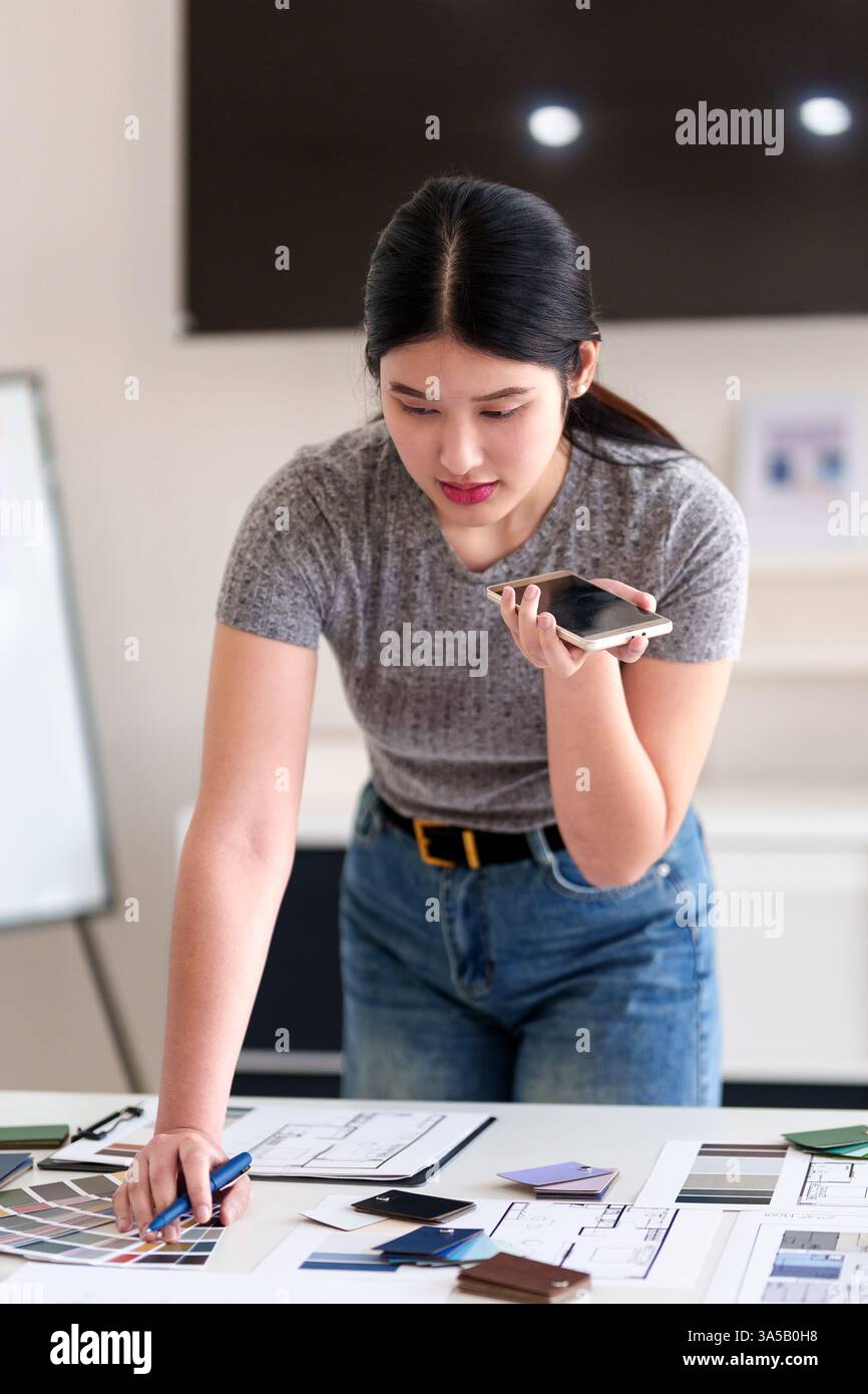Interior designer discussing project on phone while reviewing material ...