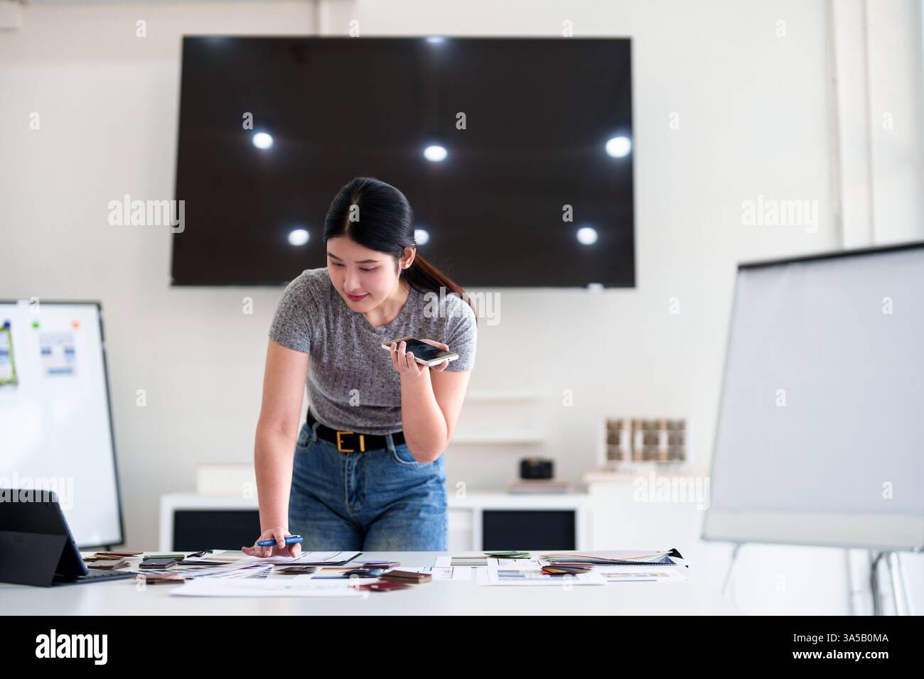 Interior designer discussing project on phone while reviewing material ...