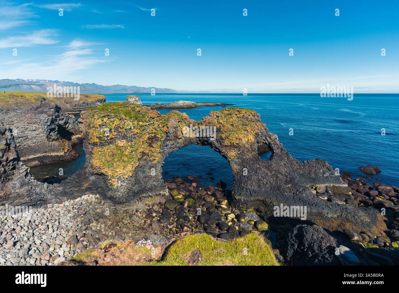 Scenic coastal view of Gatklettur Rock Arch with basalt cliff in summer ...