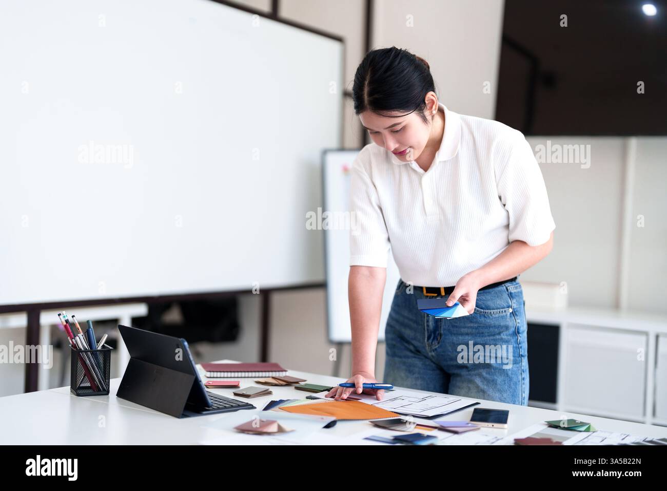 Young architect selecting materials and color swatches while standing ...