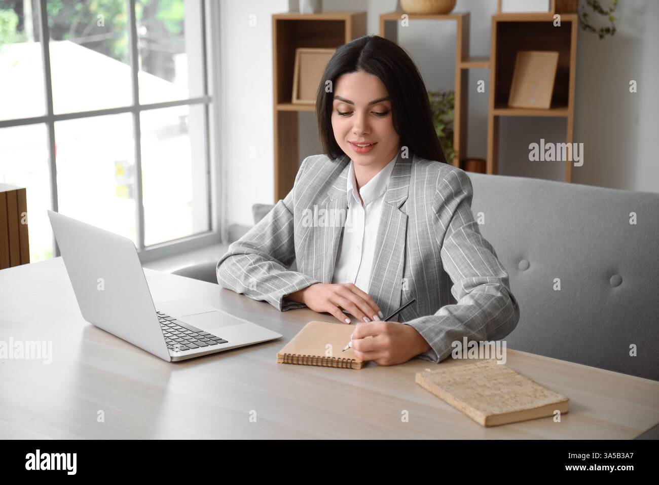 Beautiful woman writing notes during online job interview at home Stock ...
