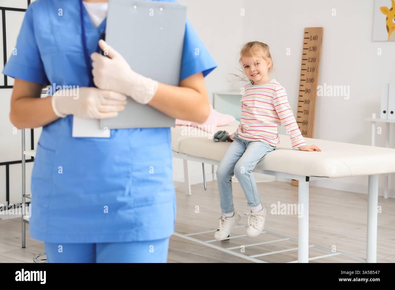 Cute little girl sitting on couch in pediatric clinic Stock Photo - Alamy