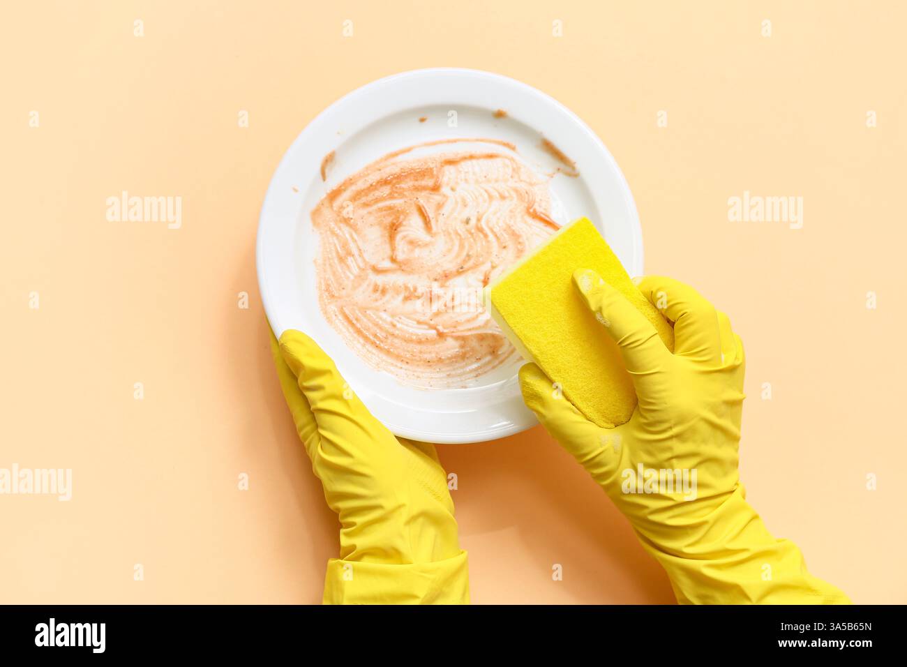 Hands washing dishes on beige background Stock Photo - Alamy