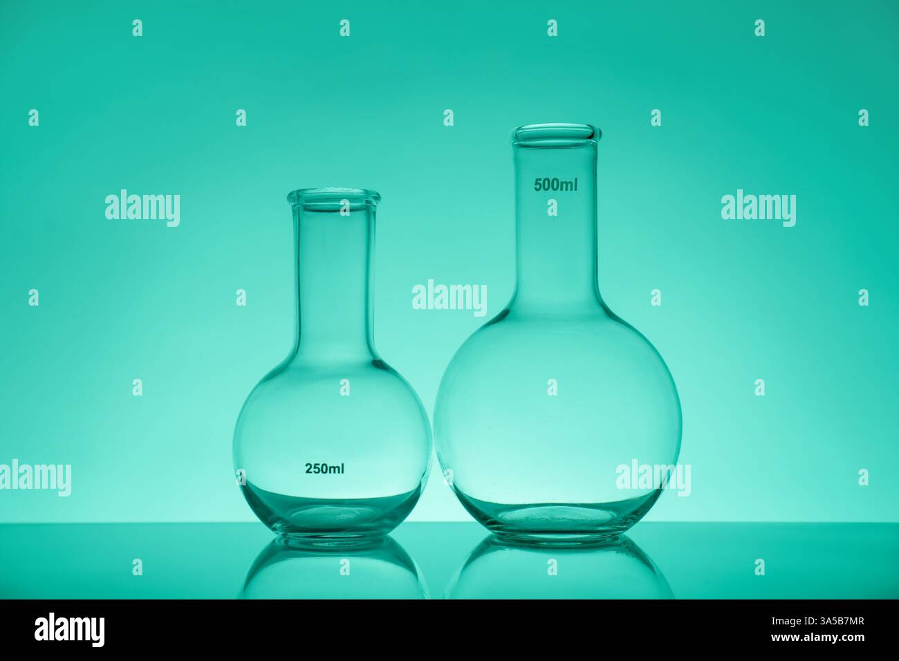 Empty flasks on mirror surface against green background. Laboratory ...