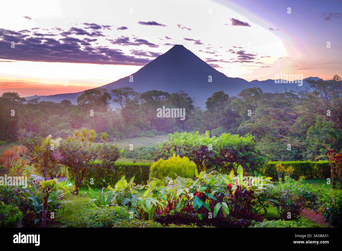 Arenal volcano, cone shaped volcano, at sunset with a purple and blue ...