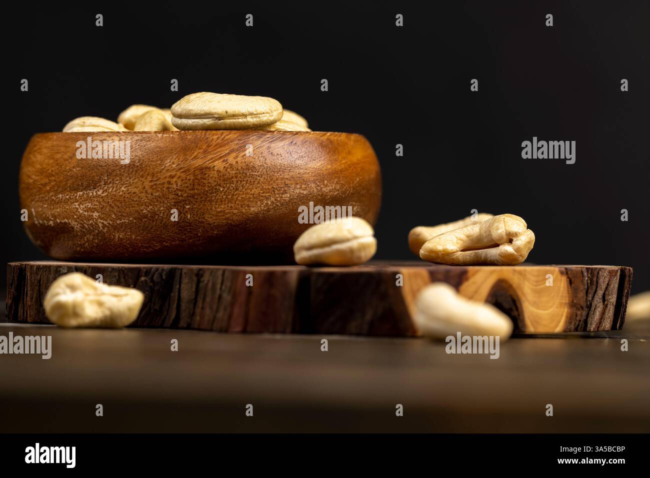 cashew nuts are scattered on a larch board, raw unroasted cashew nuts ...