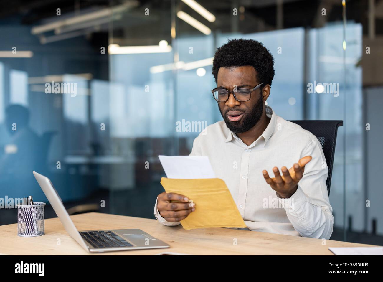 A frustrated African-American businessman reacts negatively while ...