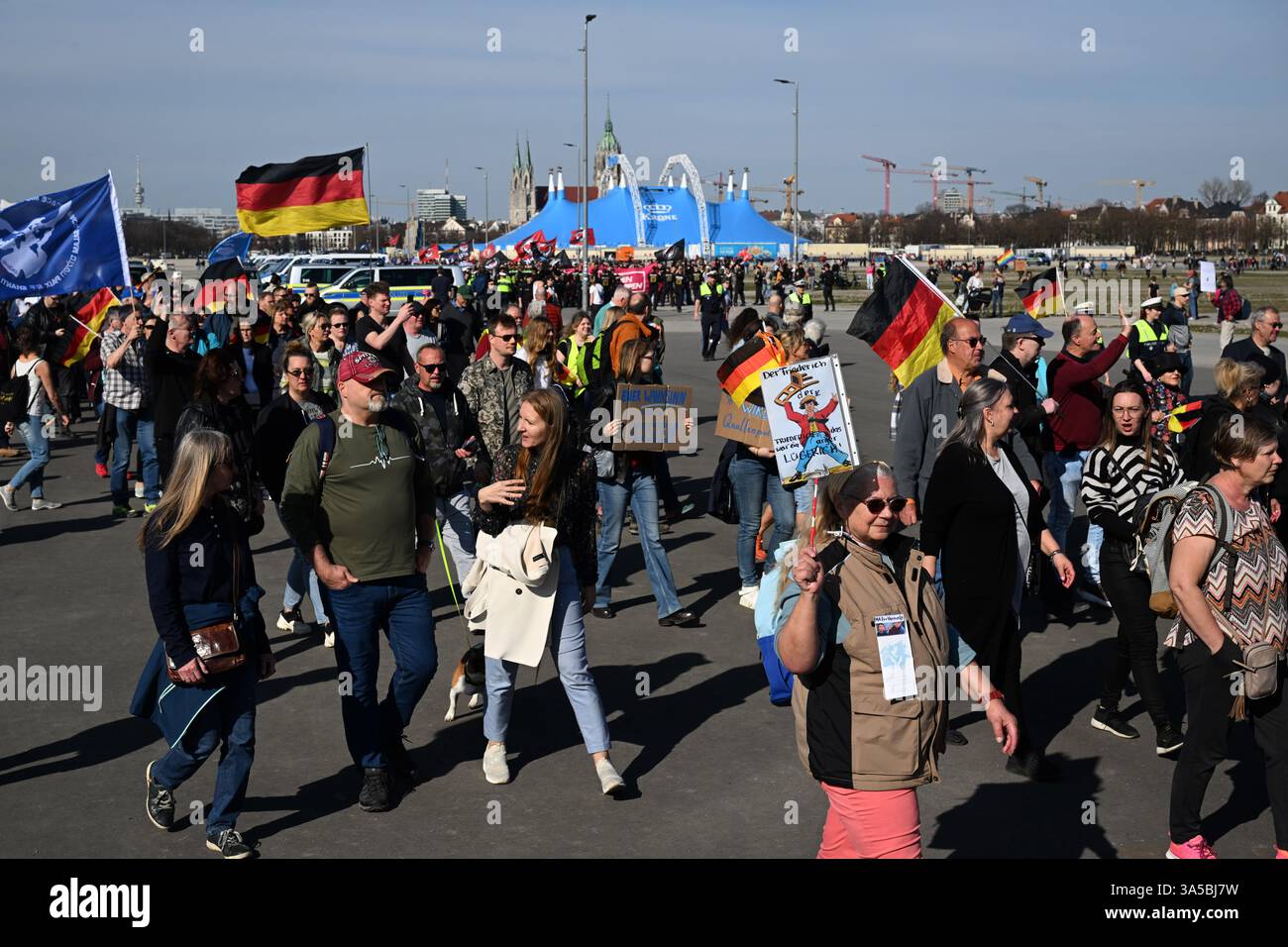 Munich, Germany. 22nd Mar, 2025. Demonstrators walk across the ...