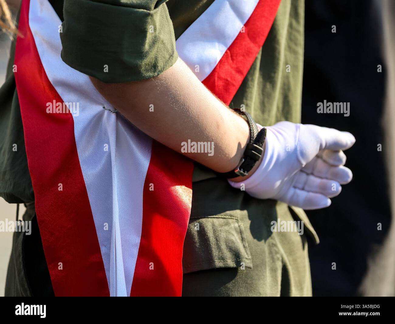 A woman wear a uniform and a Polish national colours sash as she ...