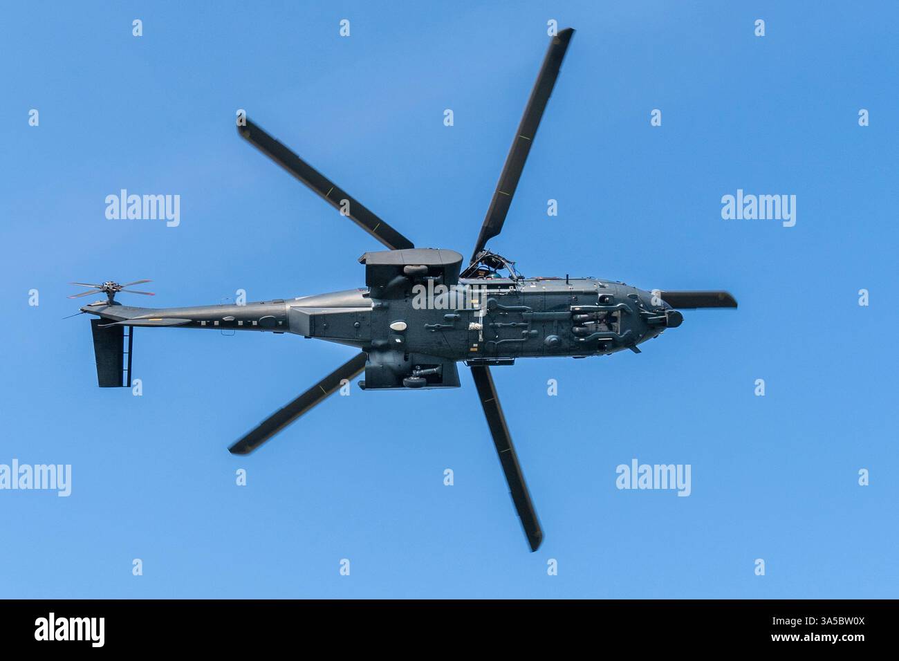 Modern military H225M transport helicopter flying in the blue sky in ...