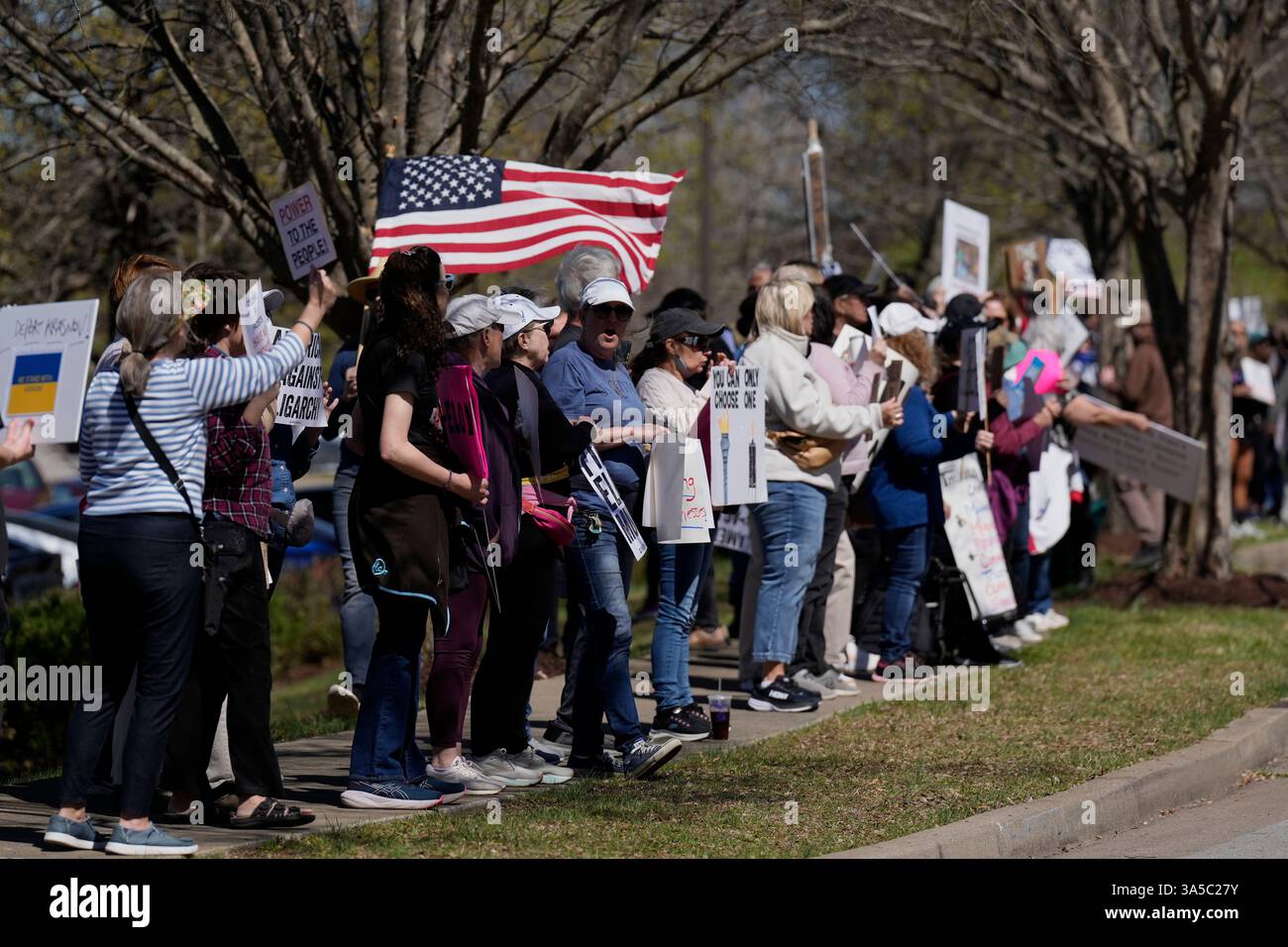 Protesters carrying signs and chant slogans against Elon Musk and ...