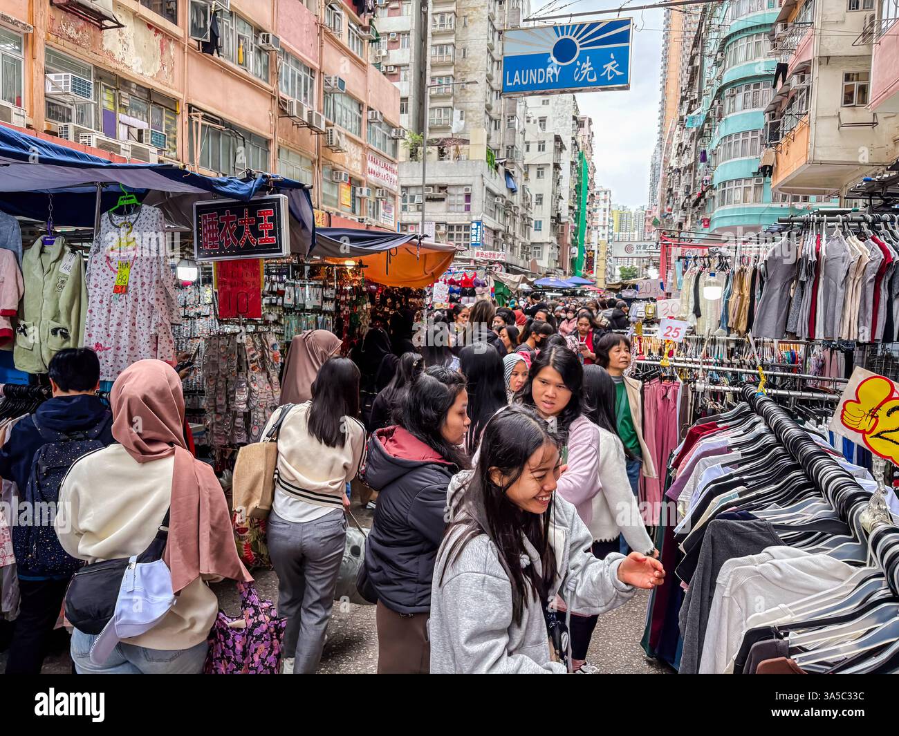 Crowded street market in Kowloon, Hong Kong, featuring clothing stalls ...