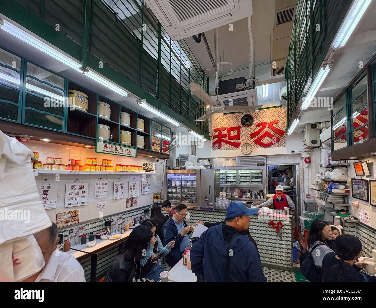 The interior of a traditional eatery in Hong Kong, showing customers at ...