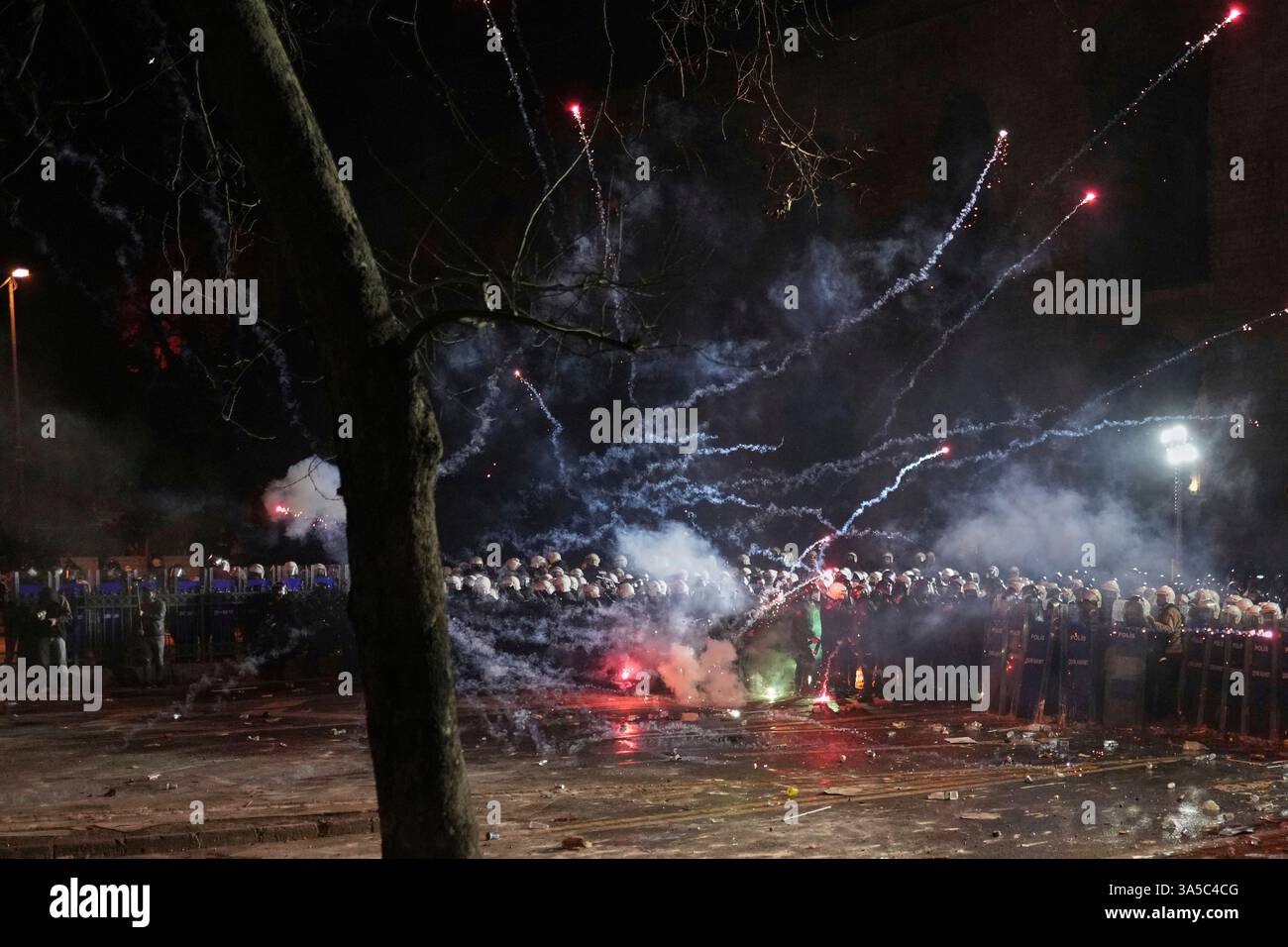 Fireworks thrown by protesters explode over riot police during a ...