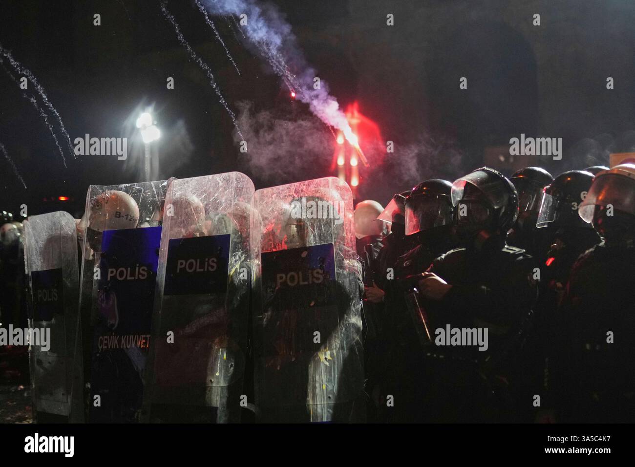 Fireworks thrown by protesters explode over riot police during a ...