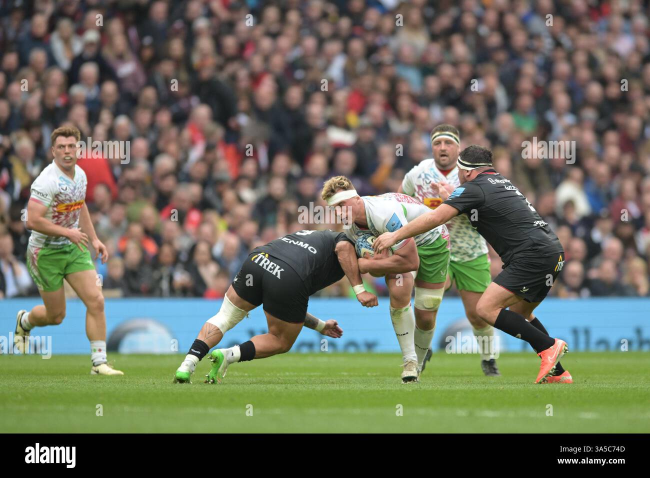 Jack Kenningham of Harlequins is tackled by Jamie George and Marco ...