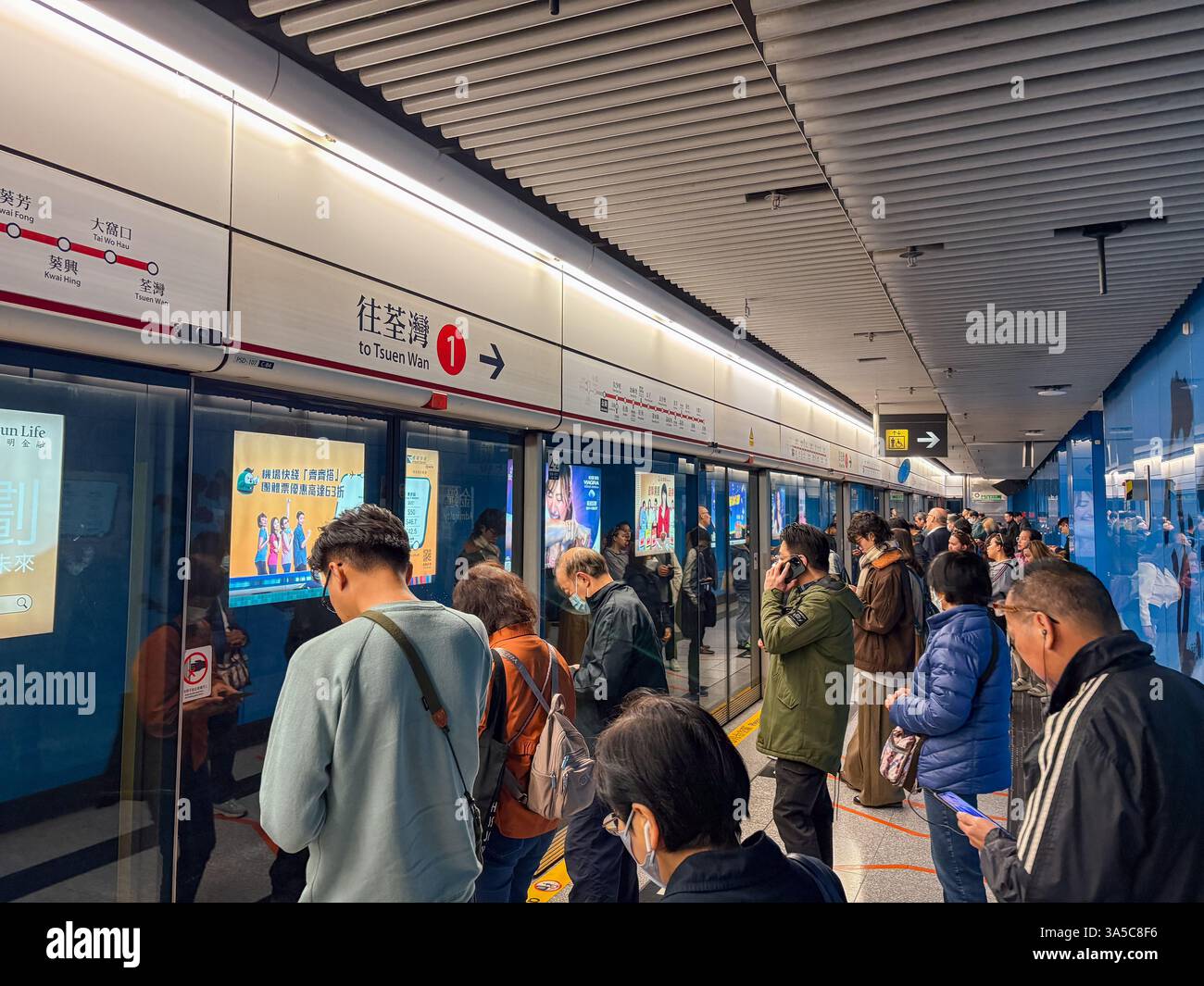 Passengers waiting to board a train at a crowded MTR platform in Hong ...