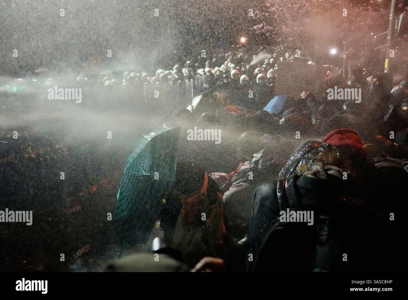 Riot police tries to clear protesters with a water canon during a ...
