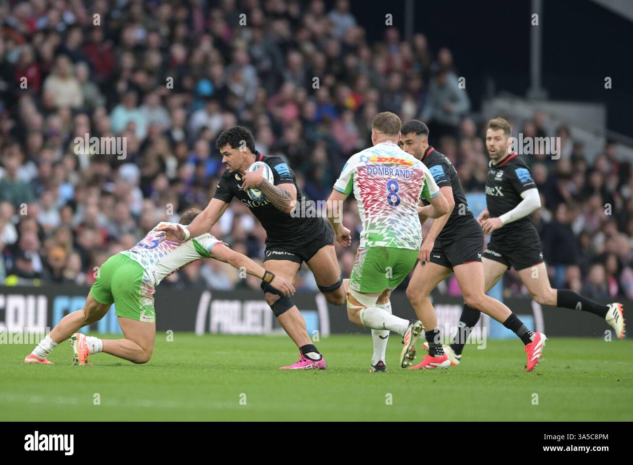 Theo McFarland of Saracens is tackled by Oscar Beard of Harlequins ...