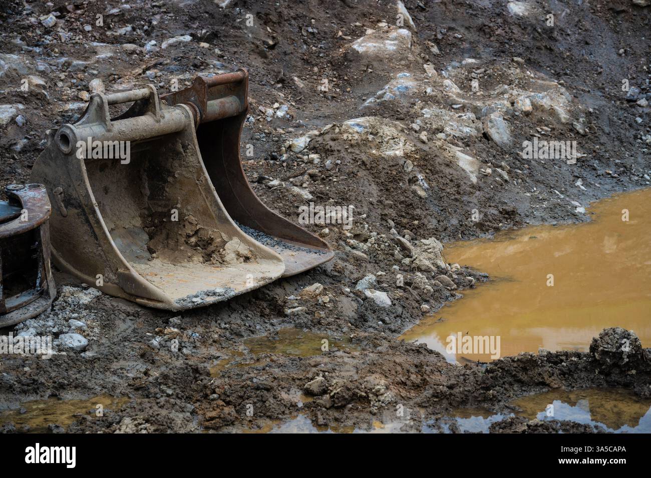excavator buckets in muddy construction site Stock Photo - Alamy