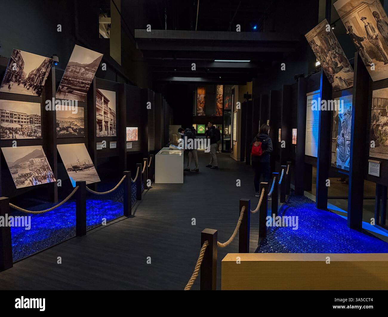A dark exhibit at the Hong Kong Museum with glowing blue accents and ...