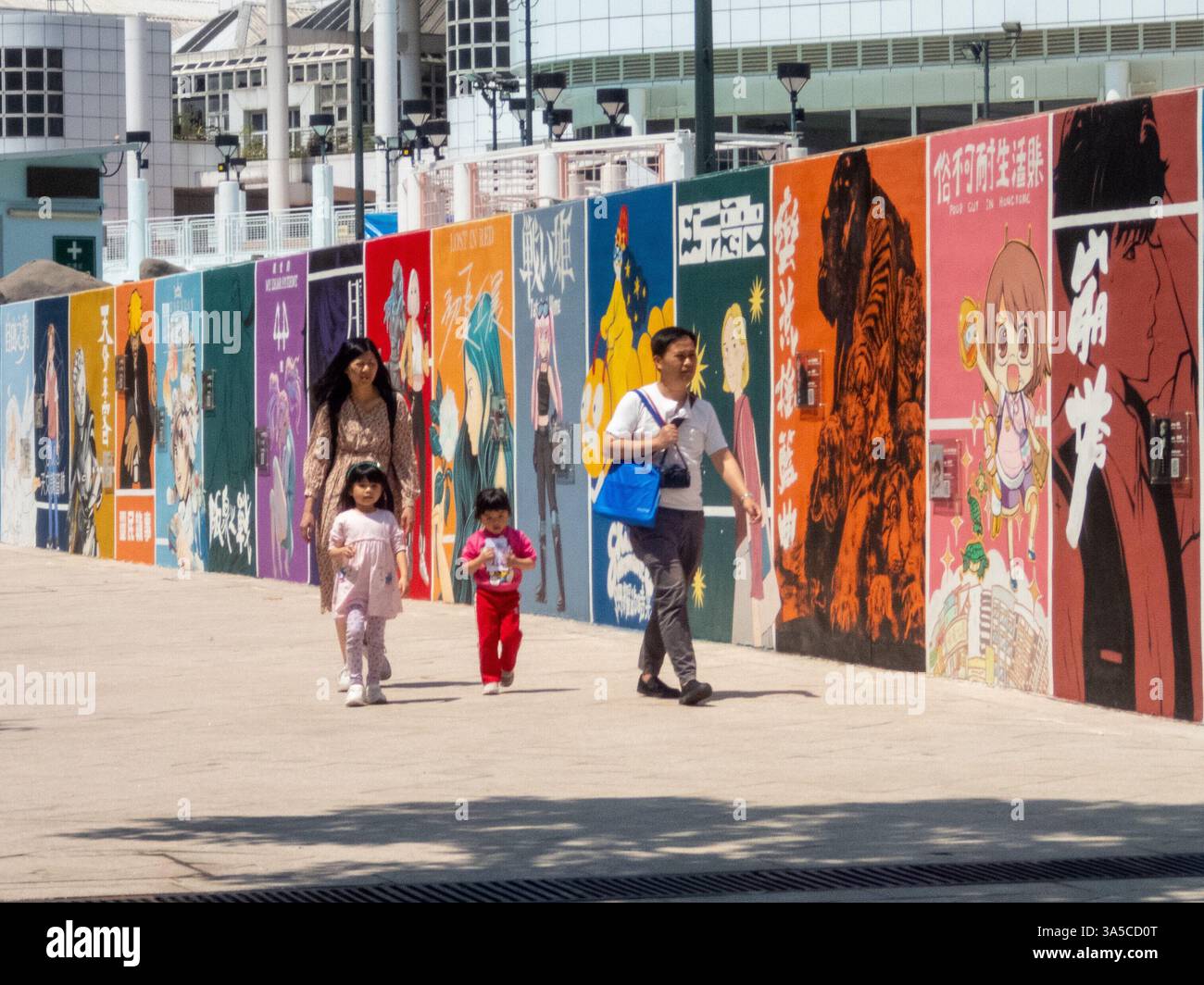 Visitors walk past the comic wall at the Hong Kong Avenue of Comic ...