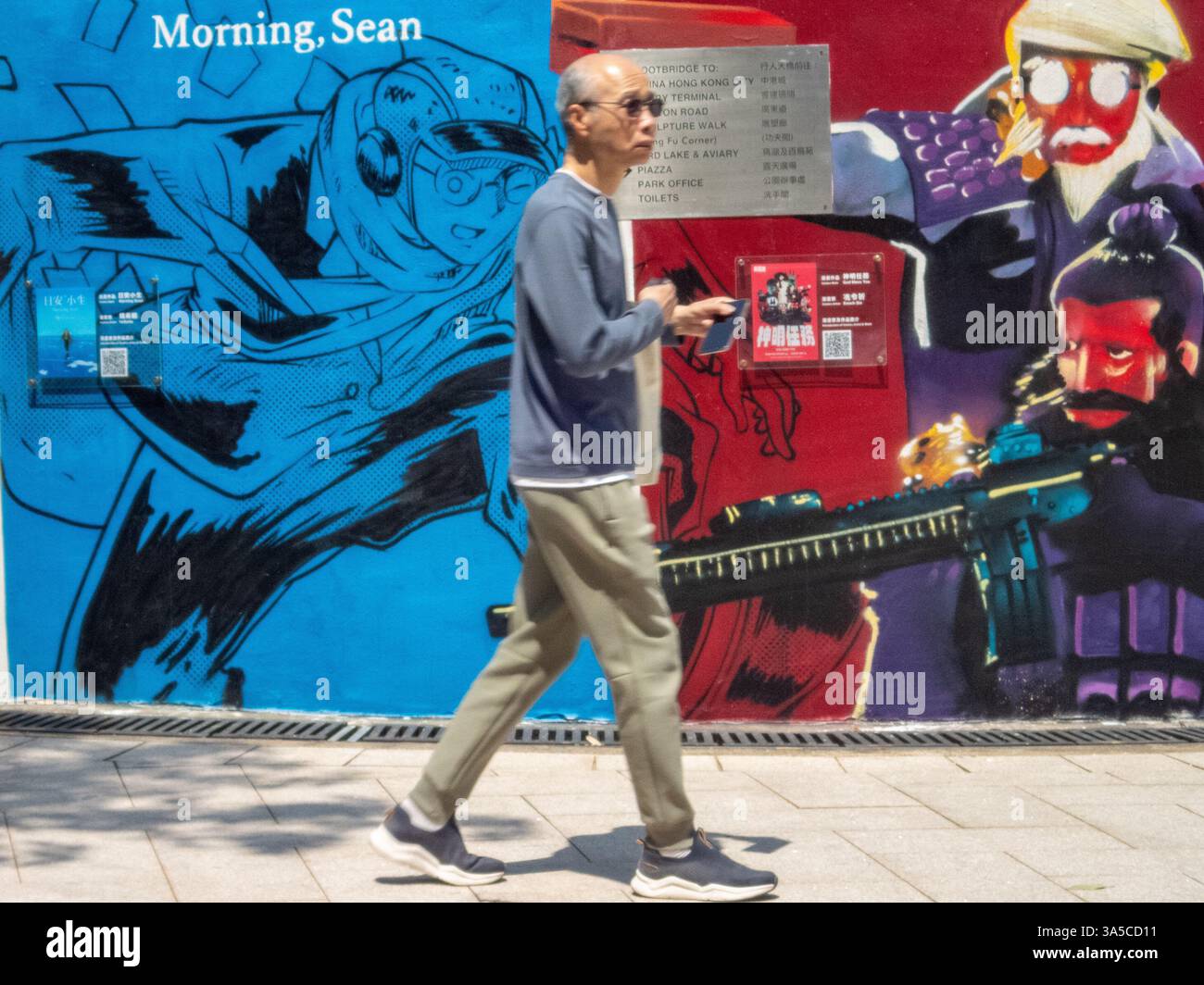 A visitor walks past the comic wall at the Hong Kong Avenue of Comic ...