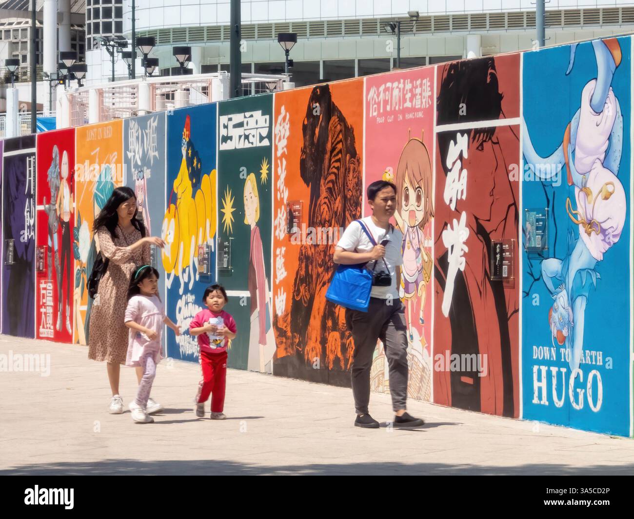 Visitors walk past the comic wall at the Hong Kong Avenue of Comic ...