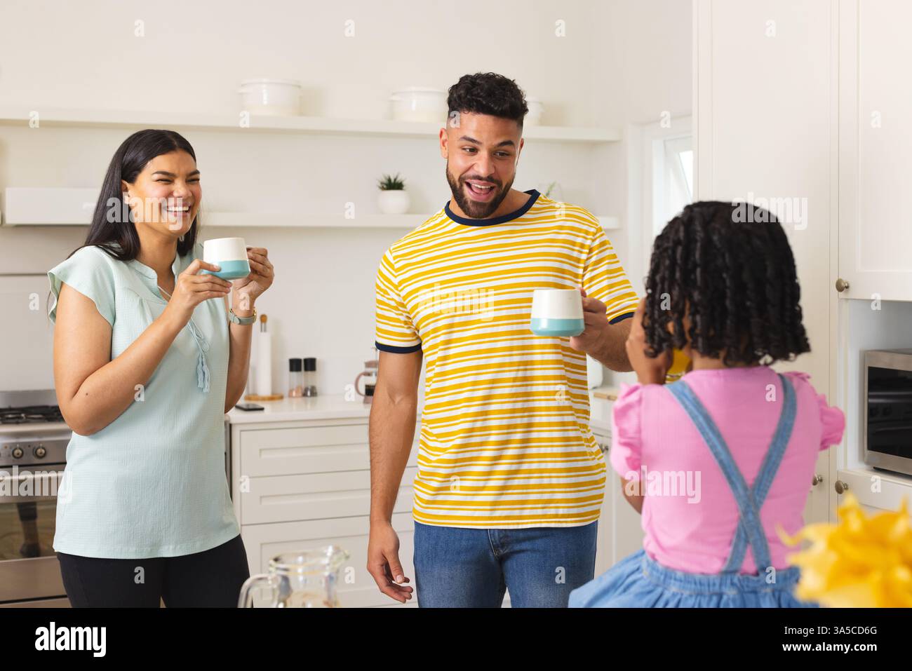 Family enjoying morning coffee together in kitchen, smiling and bonding ...