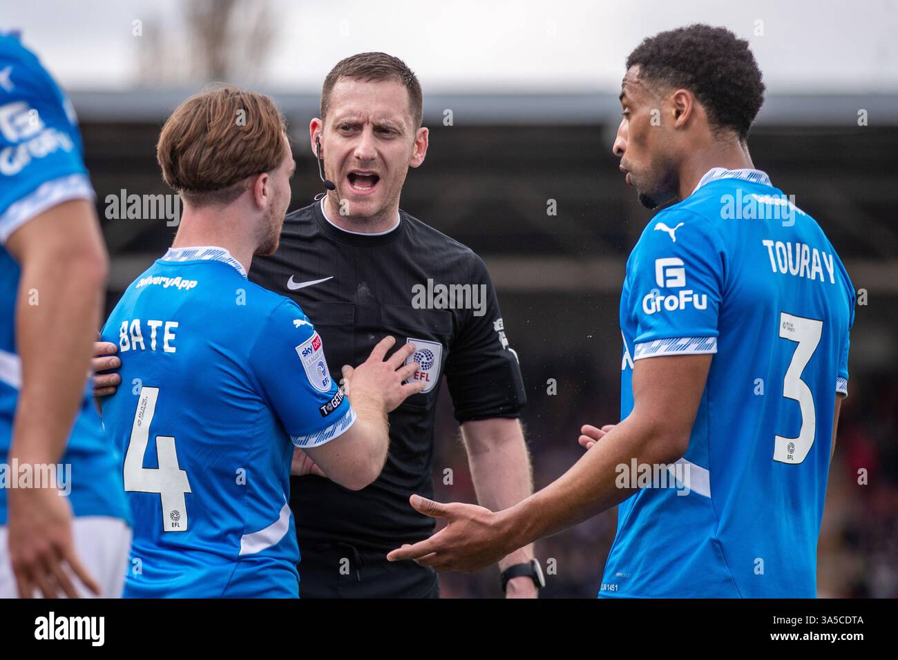 Referee Simon Mather speaks to Stockport County players after awarding ...