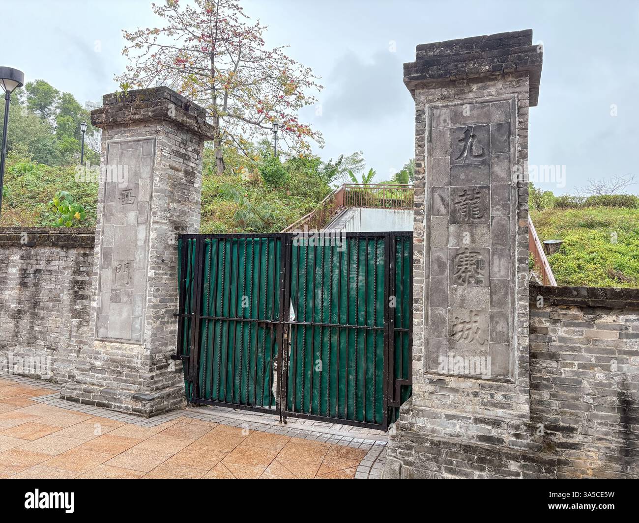 Stone entrance to Kowloon Walled City Park with closed gate in Hong ...