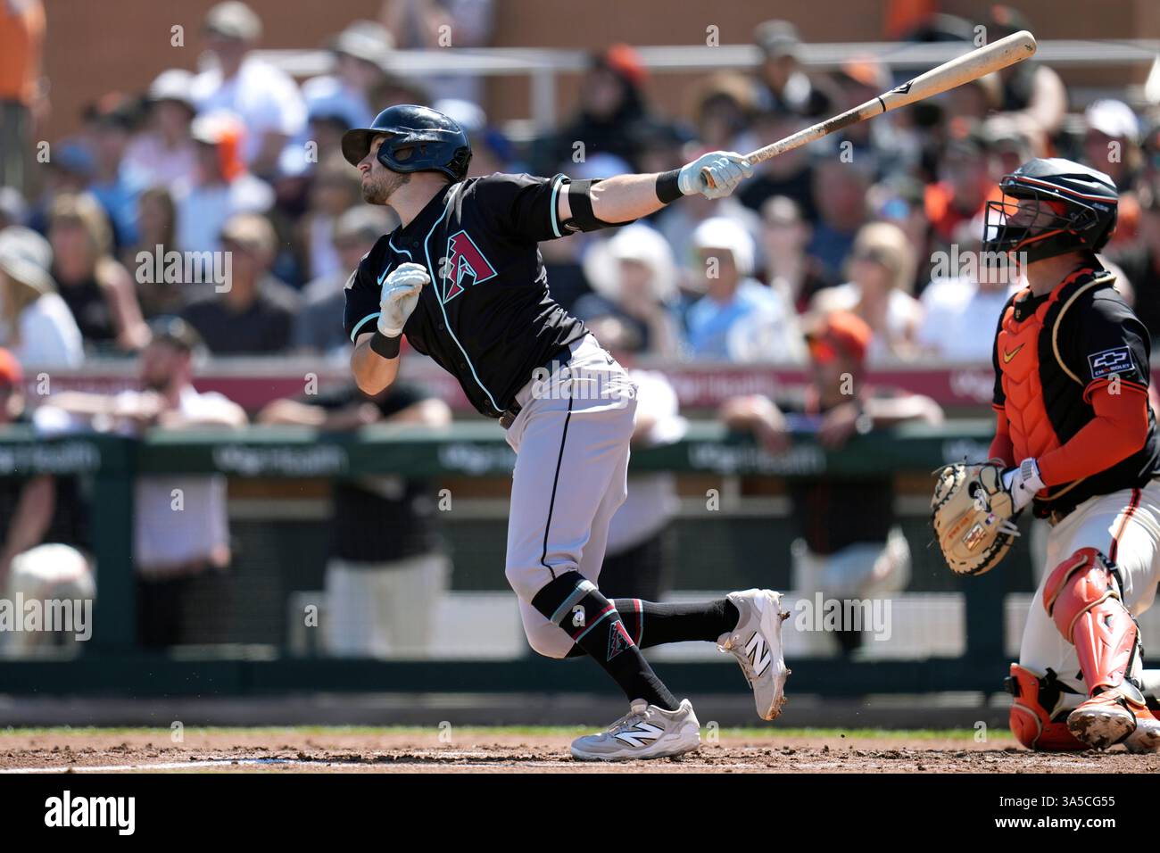 Arizona Diamondbacks' Garrett Hampson, left, watches the flight of his ...