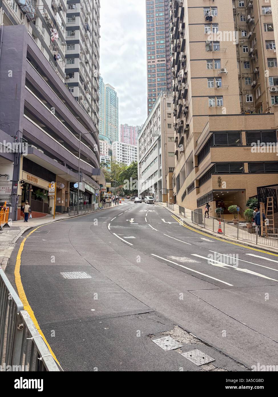 Street scene in Fortress Hill, Hong Kong. A road curves upwards between ...