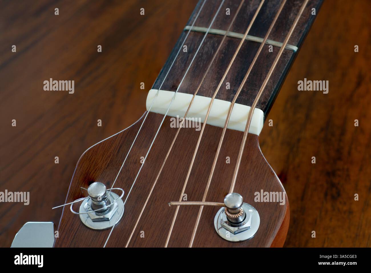 Acoustic guitar close up of tuning machines and nut Stock Photo - Alamy