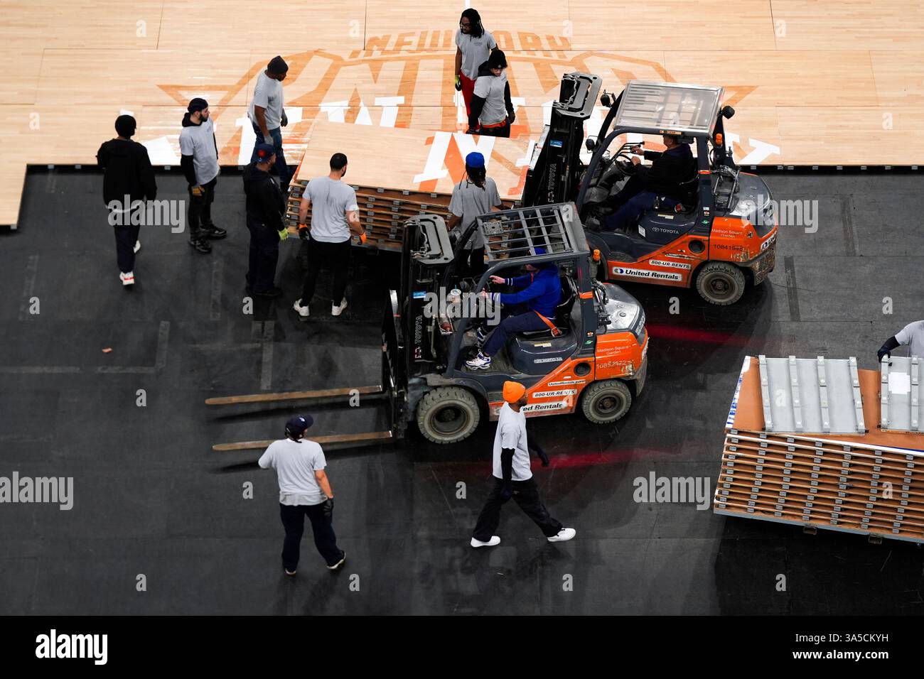 Workers install the basketball court over the ice at Madison Square ...